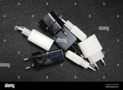 Many Phone Charger Adapters Of Different Types On A Black Background
