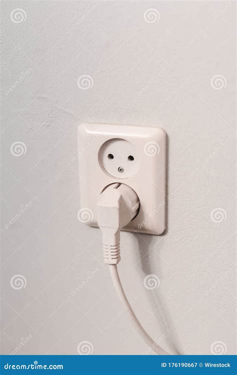 Plugged Into The Electrical Socket And Microphone Jack On The Floor Power Cable Royalty Free