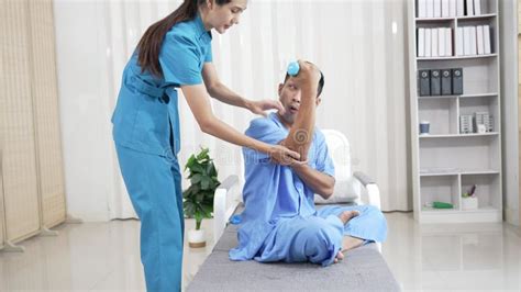 A Nurse Helps With Physical Therapy For A Male Patient At The Hospital
