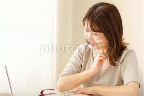 手帳を見ながら予定を考える若い女性 No 27108462｜写真素材なら「写真ac」無料（フリー）ダウンロードok
