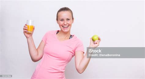 주스 한 잔과 사과 젊은 여 자가 들고 백인 여자는 행복 스포츠 스포츠 옷에서 소녀에에서 소녀는 웃 고 감정 덤벨에 대한 스톡