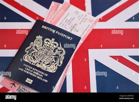 Blue British Passport With Airline Tickets On National Flag Background