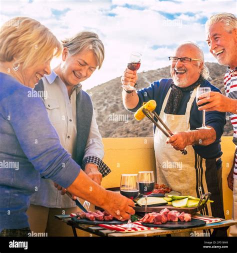 Happy Group Of Elderly Senior People Couples Eating Bbq Grill All