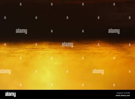 Natural Light Reflection Through Yellow Glass Onto A Wooden Surface Creating A Captivating