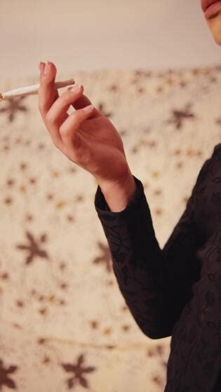 elegante persona participación un cigarrillo en un Clásico ajuste con
