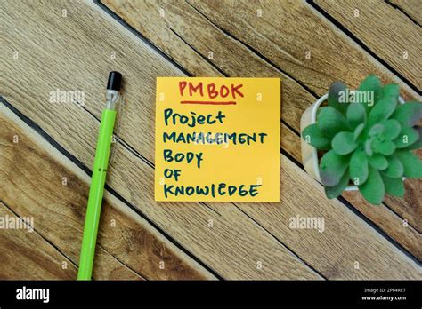 Concept Of Pmbok Project Management Body Of Knowledge Write On Sticky Notes Isolated On Wooden