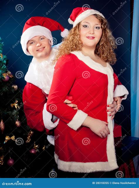 Couple In Love Wearing Santa Hats Near Christmas Tree Fat Woman And