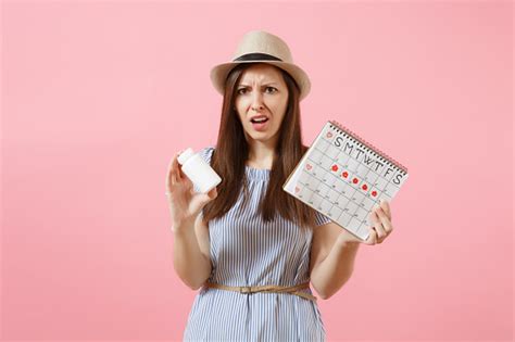 배경에 고립 된 생리 일 체크 블루 드레스 흰색 병 약 여성 기간 일정을 잡고 슬픈 여자의 초상화 의료 보건 부인과 개념 공간에
