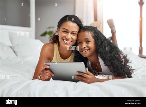Were Always Entertained By The Internet A Mom And Daughter Lying On Bed With A Digital Tablet