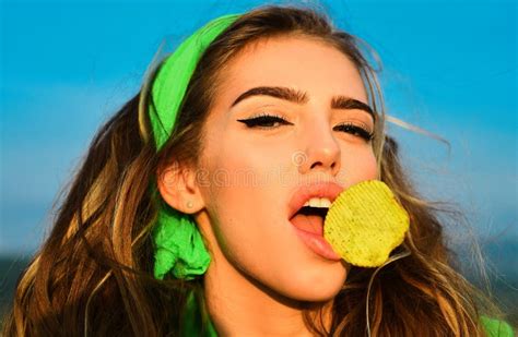 Girl Eating Chips Holding In Mouth Hungry Female Face Closeup Stock