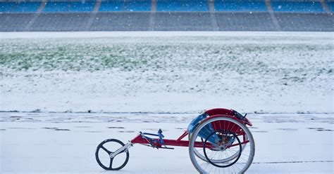 우울한 겨울 오후에 눈으로 덮인 야외 육상 경기장에 서 있는 현대 경주용 휠체어 사진 Unsplash의 스포츠 레이스 이미지