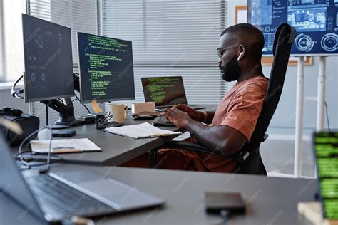 Premium Photo | Side view portrait of black software engineer working with computers in high ...