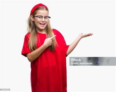 年輕美麗的女孩戴著眼鏡在孤立的背景驚訝和微笑的鏡頭 同時提出用手和手指指指點點 照片檔及更多 一個人 照片 一個人 人 人手 Istock