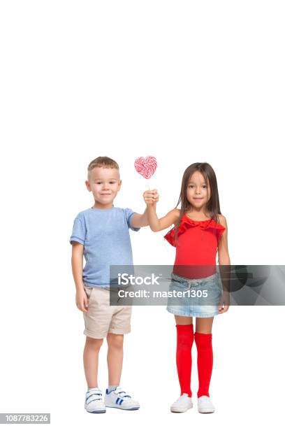 카메라를 보고 하 고 캔디와 함께 웃 고 세련 된 옷을 입고 귀여운 꼬마의 전체 길이 초상화 귀여운에 대한 스톡 사진 및 기타 이미지 Istock