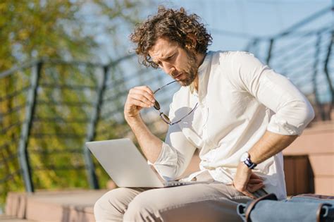 잘 생긴 젊은 성인 은 단계에 앉아 호기심 자신의 노트북을보고 생각 걱정하는에 대한 스톡 사진 및 기타 이미지 걱정하는 건강한 생활방식 계단 Istock