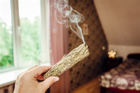 건조 세이 지 스머지 스틱 흡연의 여자 손 들고 허브 번들 그것은 부정적인 에너지를 정화 하 고 객실에서 집에서 생활 공간을 정화 하는 것으로 추정 된다 무당에 대한 스톡