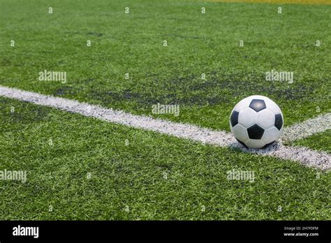Soccer Ball On The White Line On Green Soccer Field Grass Background