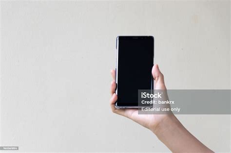 여자 잡고 8 갈색 콘크리트 벽 배경 이 휴대 전화에 안 드 로이드 운영 체제를 사용 하는 삼성 갤럭시 참고 8에 대한 스톡