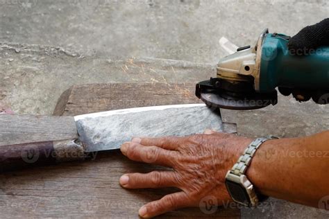 Closeup Hands Are Sharpening A Knife With Electric Sharpener Grinder Machine In Motion Action Of