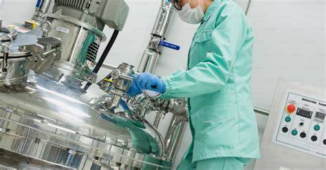 엔진이 있는 강철 크롬 도금 탱크로 작업하는 파란색 실험실 정장을 입은 과학자 사진 Unsplash의 능률 이미지