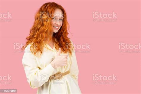 미소 짓는 빨간 머리 젊은 여성이 분홍색 배경과 복사 공간에 좋은 표시로 엄지 손가락을 보여주는 카메라를보고 개성 개념에 대한 스톡 사진 및 기타 이미지 Istock