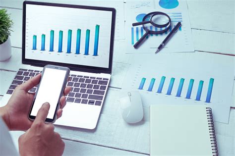 비즈니스 사람들이 작업 하는 동안 전화를 사용 하 여 분석 그래프와 노트북 컴퓨터 화면에 차트 요소와 클리핑 경로와 통계 성능 금융에 대한 스톡 사진 및 기타 이미지