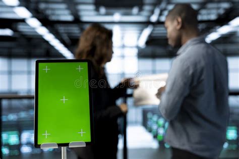Close Up Of Chroma Key Tablet Next To Workers Supervising Data Center