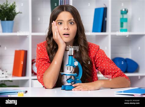 School Girl With Microscope For School Education At Home Surprised