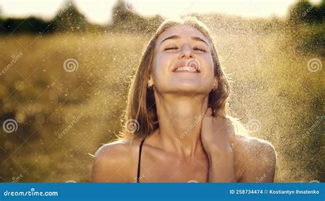 Portrait Of A Beautiful Young Blonde Girl Under Light Summer Rain In