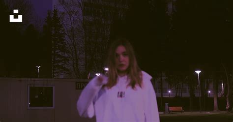 하얀 긴팔 셔츠를 입은 여자가 밤 시간 동안 푸른 잔디밭에 서 있습니다 사진 Unsplash의 무료 소녀 이미지