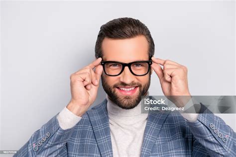 여러분 손가락으로 그의 얼굴에 안경의 2 개의 작은 구멍을 들고 하는 헤어스타일으로 사내 다운 멋진 현대 남자의 회색 배경 위에 카메라를 보면서 갈색 머리에 대한 스톡 사진