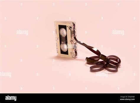 Audio Cassette With Tape Pulled Out On A Pink Background Stock Photo