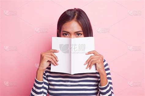 年轻的亚洲女人拿着一本书。