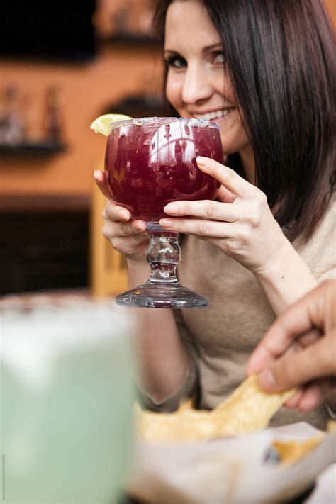 Cinco Woman Holding Large Fruit Margarita At Dinner By Stocksy