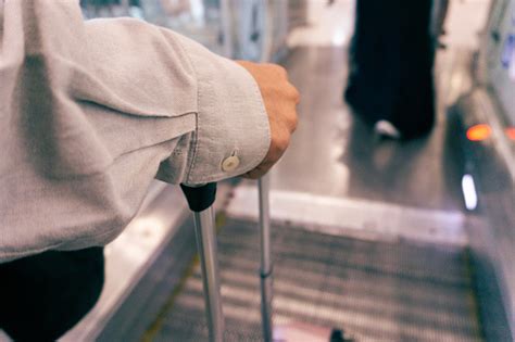 국제 공항에 도착하는 엘리베이터로 여행하는 휴가 중 수하물을 가지고 공항의 에스컬레이터 또는 환승 항공편에서 여행 가방을 들고 여행자 남성 여자 사업가에 대한 스톡 사진 및