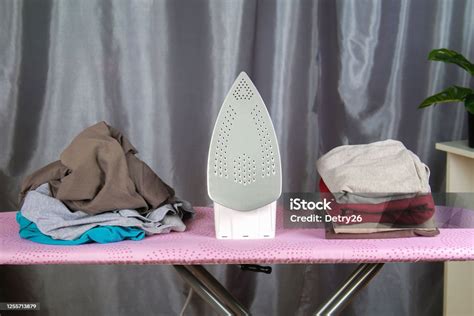 한 남자가 다림질 판에 전기 철로 린넨을 쓰다듬습니다 가정 다리미판에 대한 스톡 사진 및 기타 이미지 다리미판 0명 가사