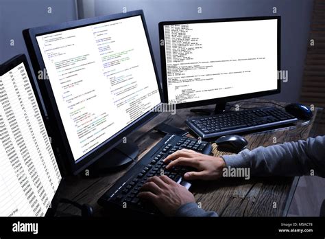 Side View Of Hacker Stealing Information From Multiple Computers On