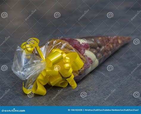 Close Up T Cellophane Cone Full Of Luxury Dried Fruit Chocholate Nuts With Yelow Topknot On