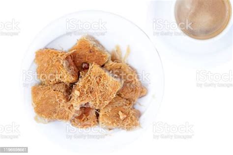 커피 한 잔과 함께 흰색 접시에 갓 만든 아라비아 바클라바를 식욕을 돋우고 있습니다 위에서 볼 수 있습니다 전통 동양 과자 음식