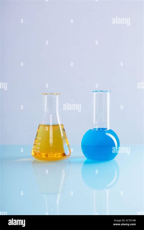 Vertical Shot Of Erlenmeyer Flask With Yellow Liquid And A Round Flask