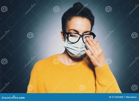 Woman Wiping Foggy Glasses Caused By Wearing Disposable Mask Stock