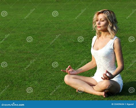 Blonde Girl Meditating On Green Grass Beautiful Young Woman Seating In