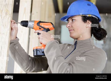 Side View Of Female Builder Using Cordless Drill Stock Photo Alamy