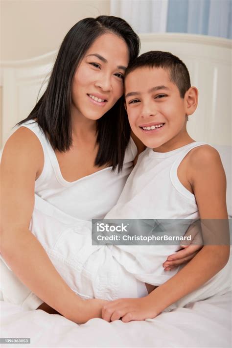 Foto De Mãe Asiática Feliz Abraçando O Filho Na Cama E Mais Fotos De