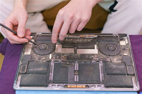 사람의 손은 먼지와 더러운 노트북에서 냉각 팬을 청소합니다 구성 요소 냉각기 설비 냉각 오물 장치 수리하다 복구 깨진 전자 먼지 하드웨어 서비스 더럽다 컴퓨터 개선에 대한