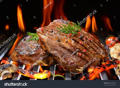 구운 쇠고기 스테이크와 불꽃 그릴에 채소를 스톡 사진 686405350 Shutterstock