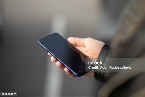 손에 휴대 전화를 들고 인식 할 수없는 청년의 클로즈업 샷 흐릿한 배경 도시에 대한 스톡 사진 및 기타 이미지 도시 말하기