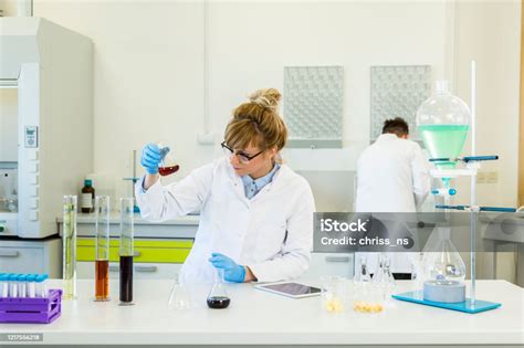 실험실에서 대마 Cbd 및 Cbda 오일과 함께 일하는 안경을 착용한 여성 화학 과학자 그녀는 라텍스 장갑 유리 튜브 및