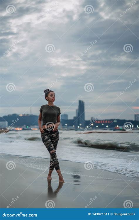 A Young Girl Enjoys A Walk On The Ocean Evening Walk On A Deserted