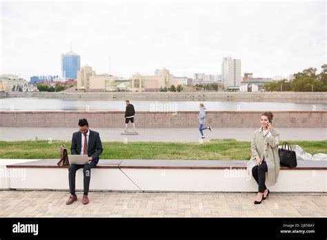 Busy People Sitting On Bench In City Park And Working Outside Keeping